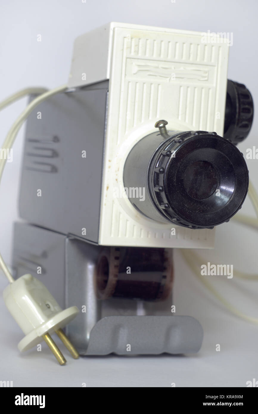 Vintage slide projector loaded with film. Front view on lens. Closeup ...