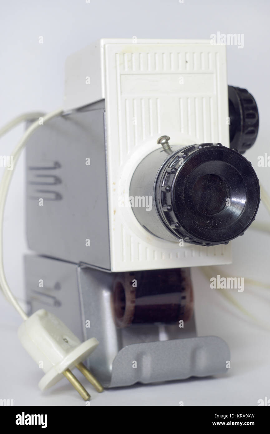 Vintage slide projector loaded with film. Front view on lens. Closeup ...