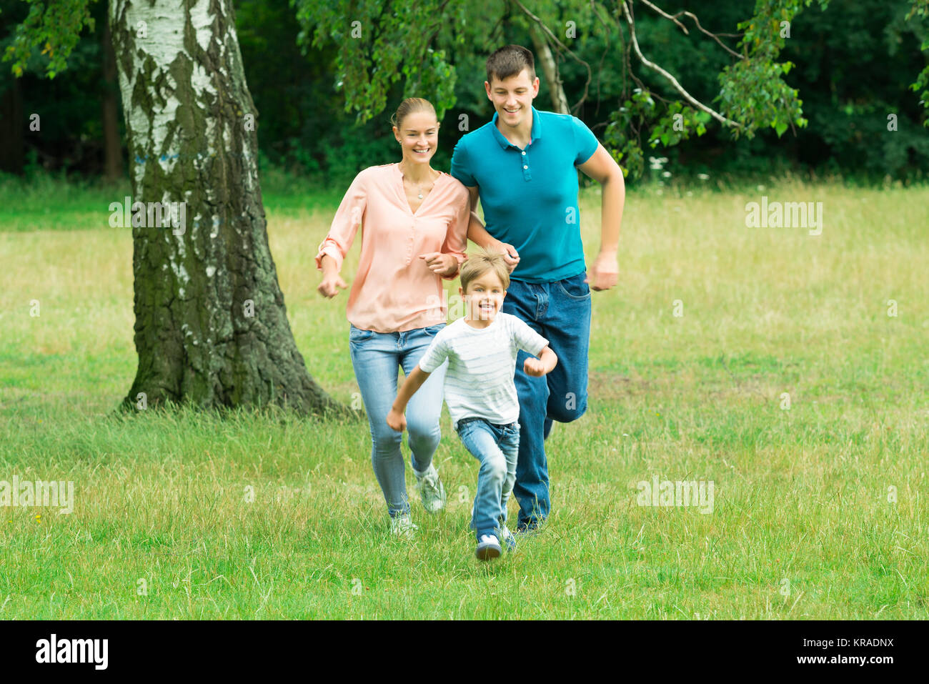 Boy Running Ahead Of His Parent Stock Photo - Alamy