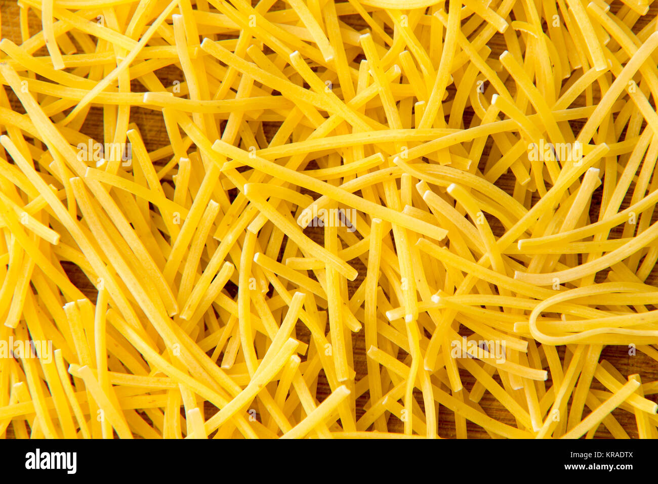 Small dry pasta noodles on wood background or texture Stock Photo - Alamy