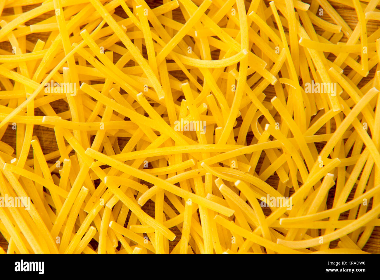 Small dry pasta noodles on wood background or texture Stock Photo - Alamy