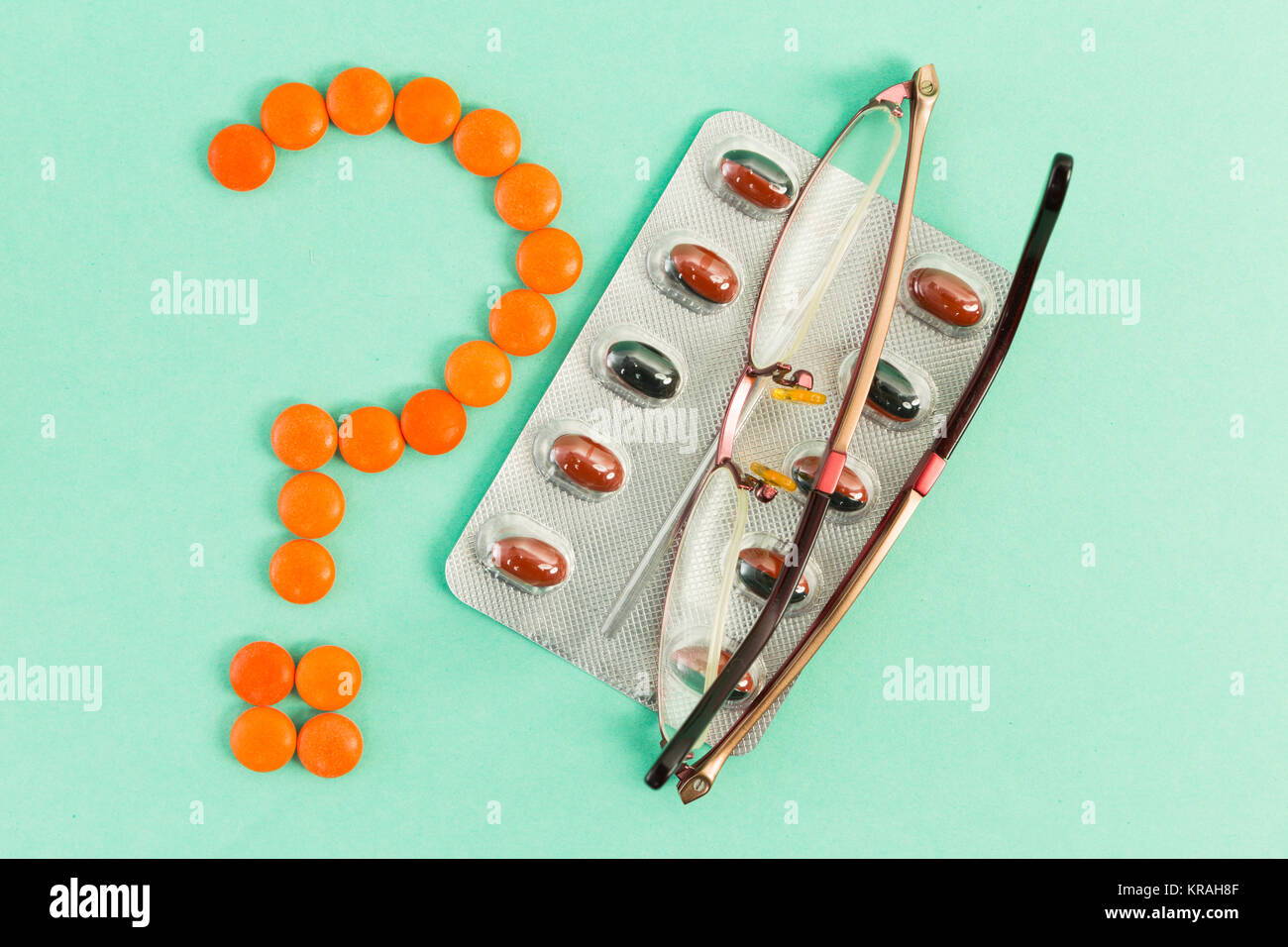 Question mark made of pills and spectacles near blister of tablets as ...