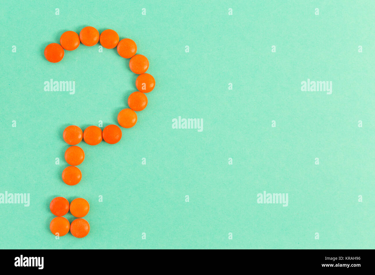 Question mark shape made of tablets or pills on medical green copy text ...