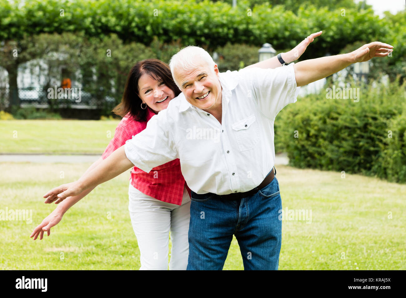 Senior Couple Making Flying Gesture Stock Photo - Alamy