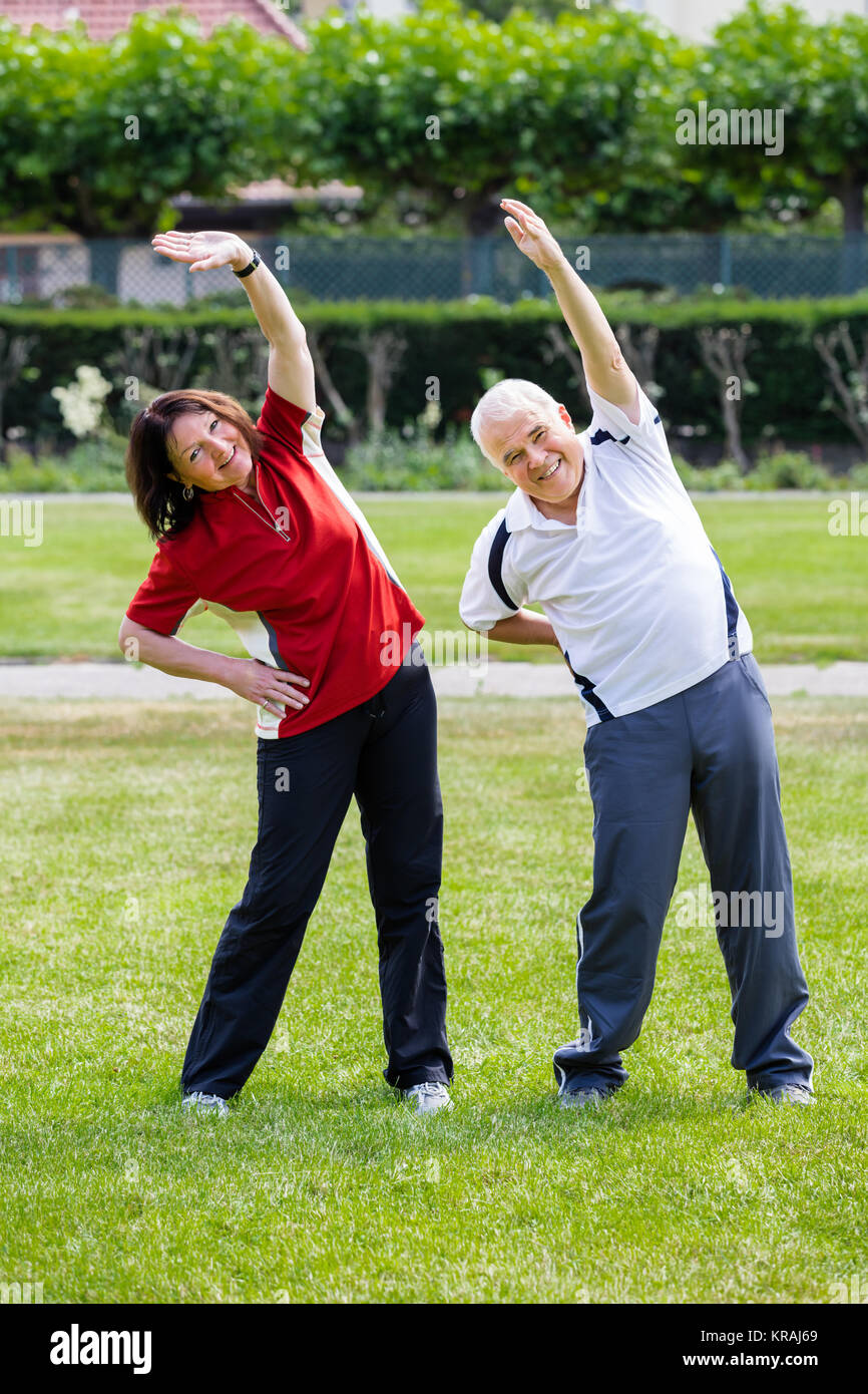 Active mature couple performing stretching hi-res stock photography and ...
