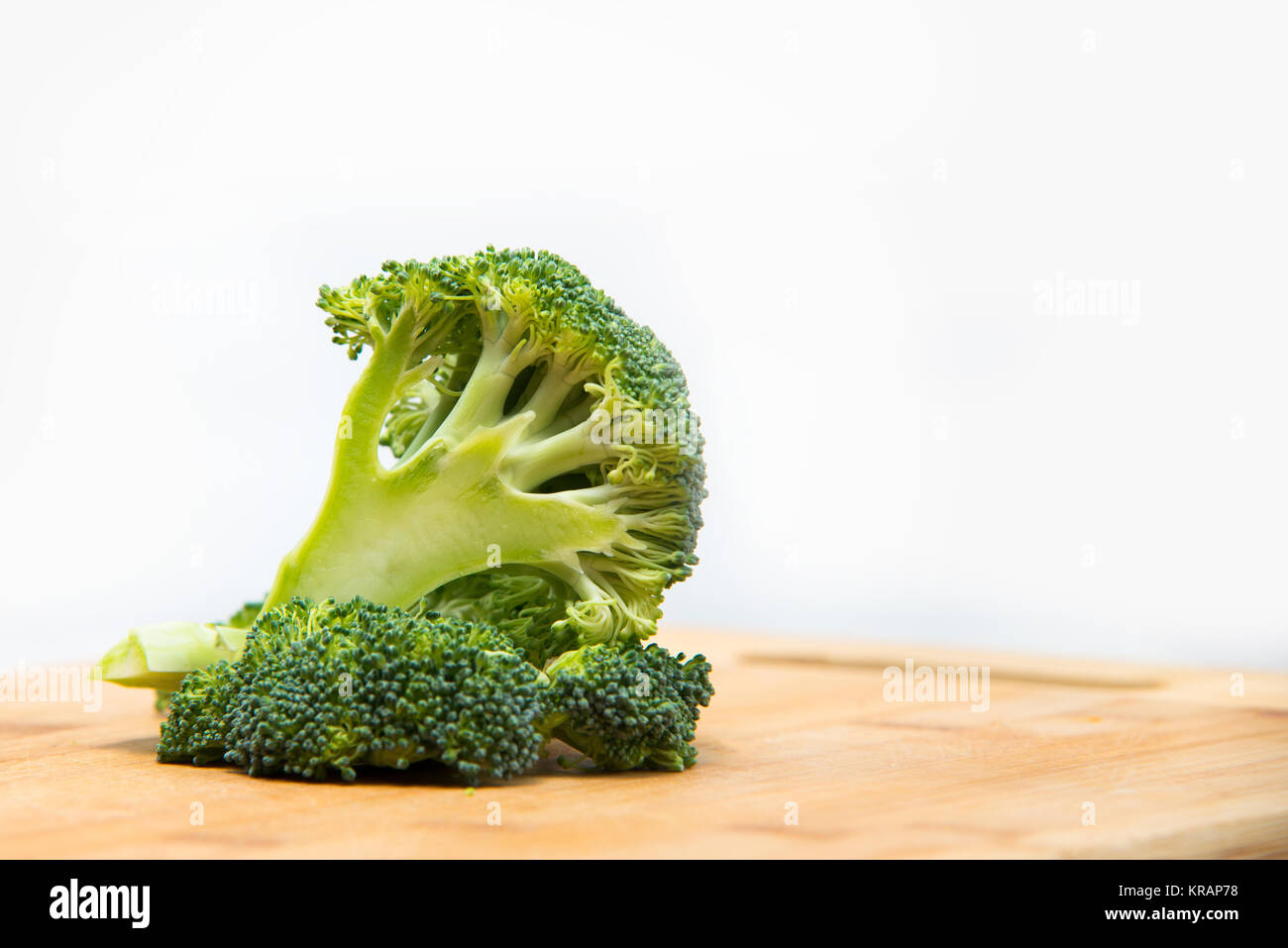 close up on fresh broccoli solated on wooden and white background Stock ...
