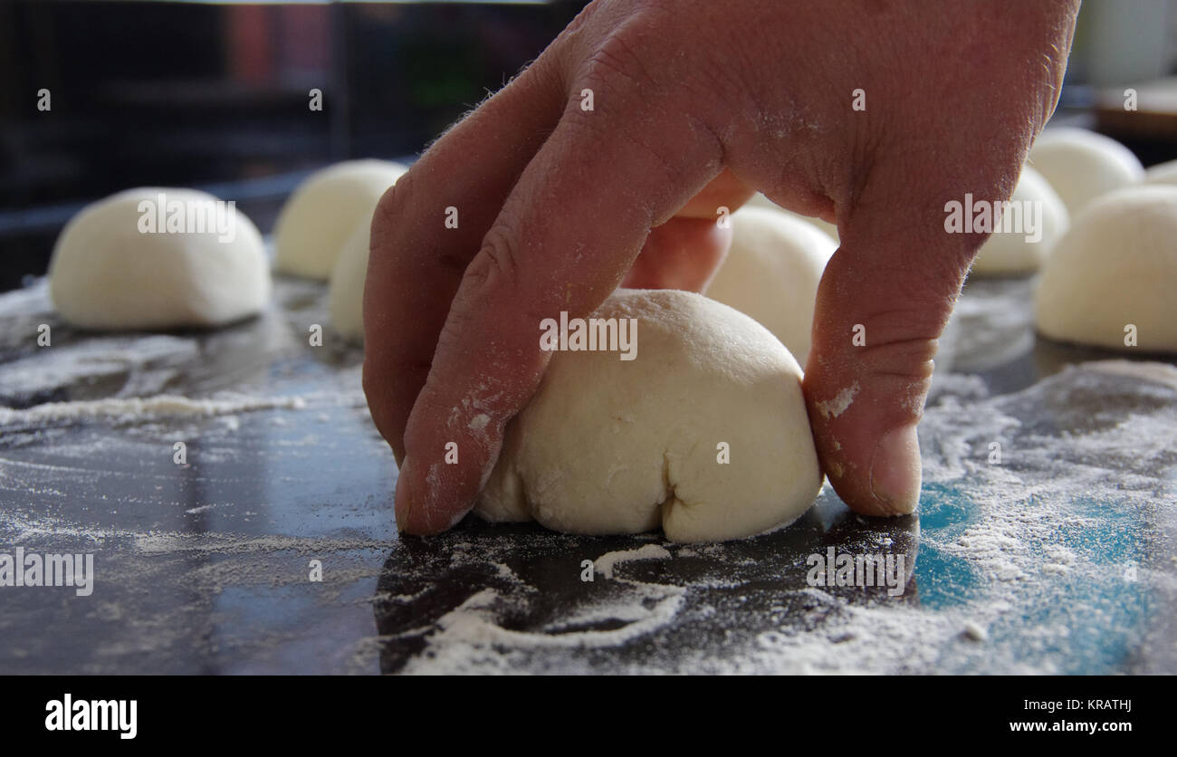 Hand making dough balls on kitchen table Stock Photo - Alamy
