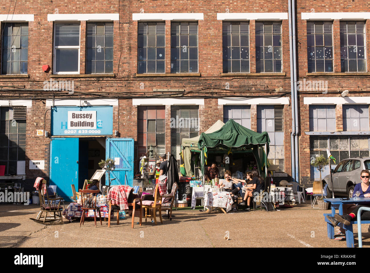 Outdoor stalls hipster cafe with people enjoying the summer at the ...