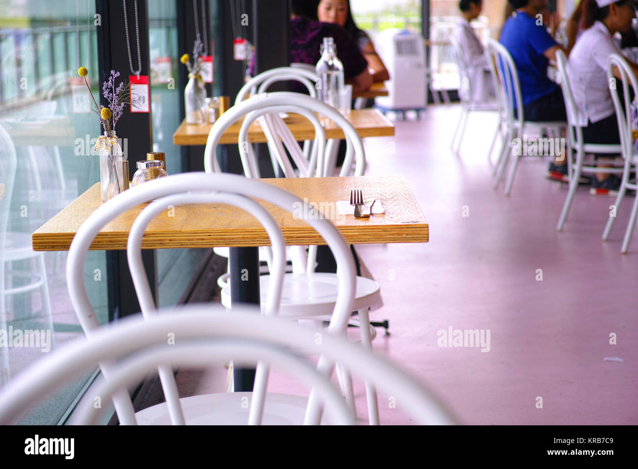 Bright modern cafe interior with big windows, wooden tables and white ...