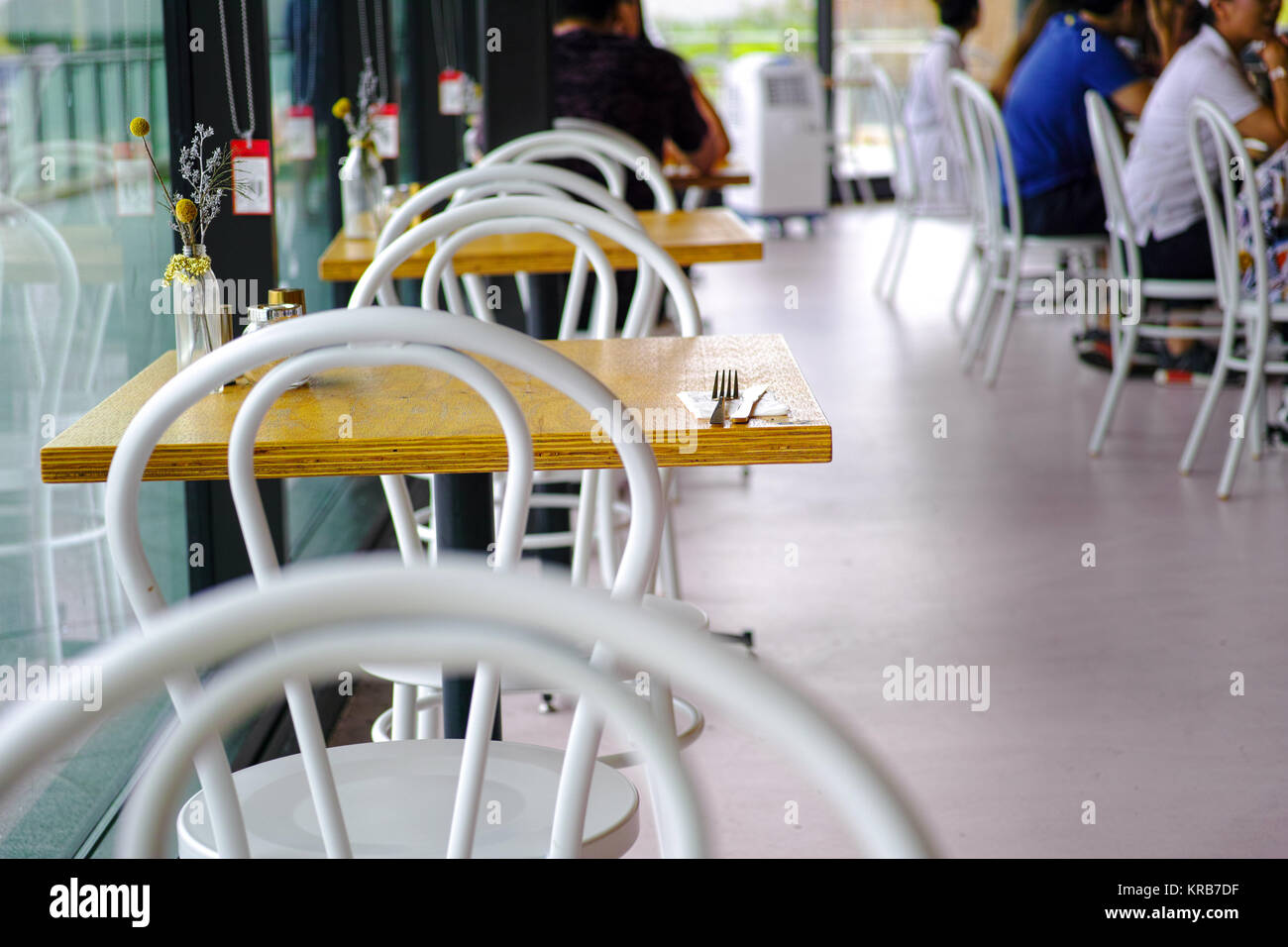 Bright modern cafe interior with big windows, wooden tables and white ...