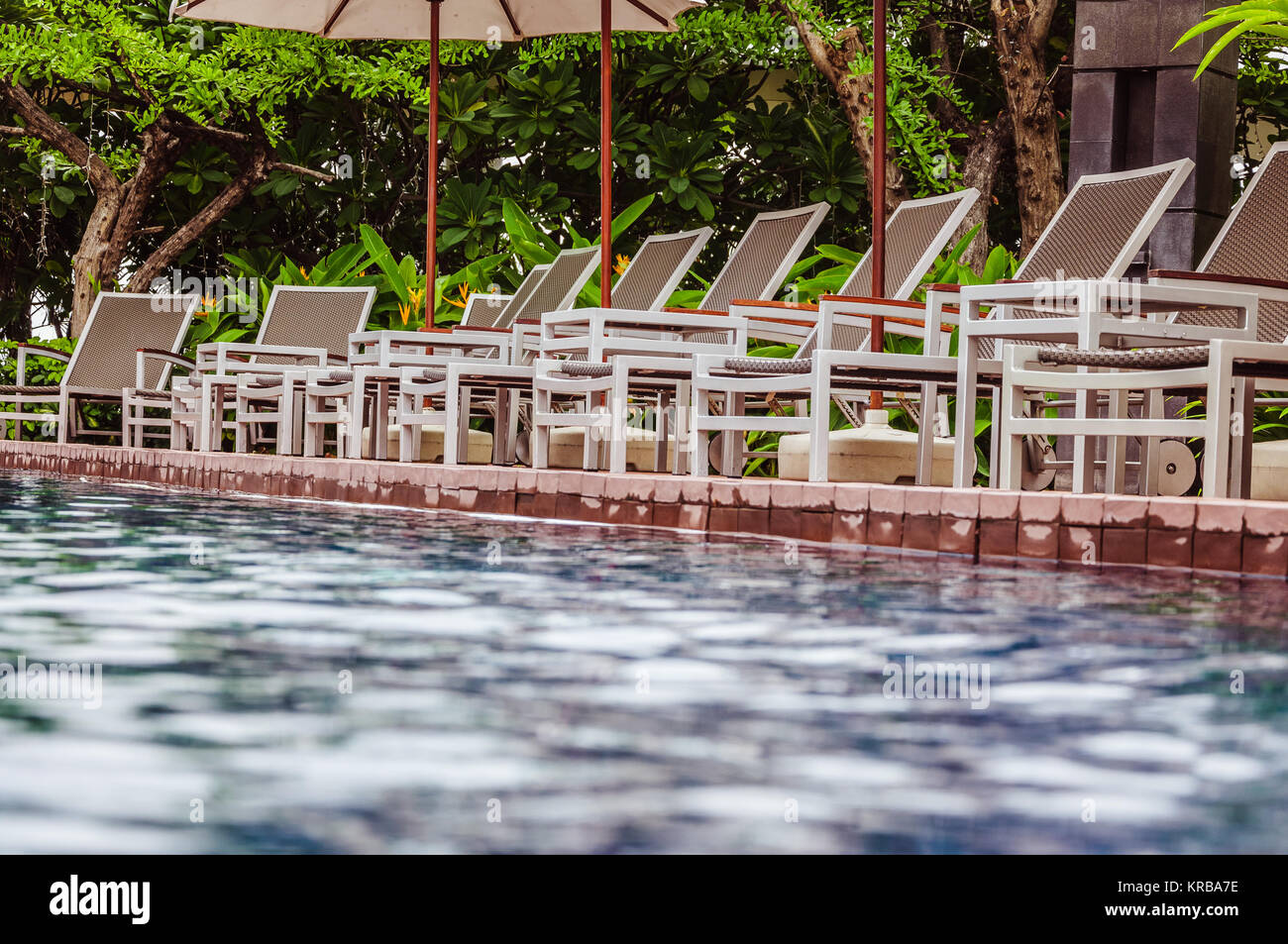 Comfortable chairs near hotel pool Stock Photo - Alamy