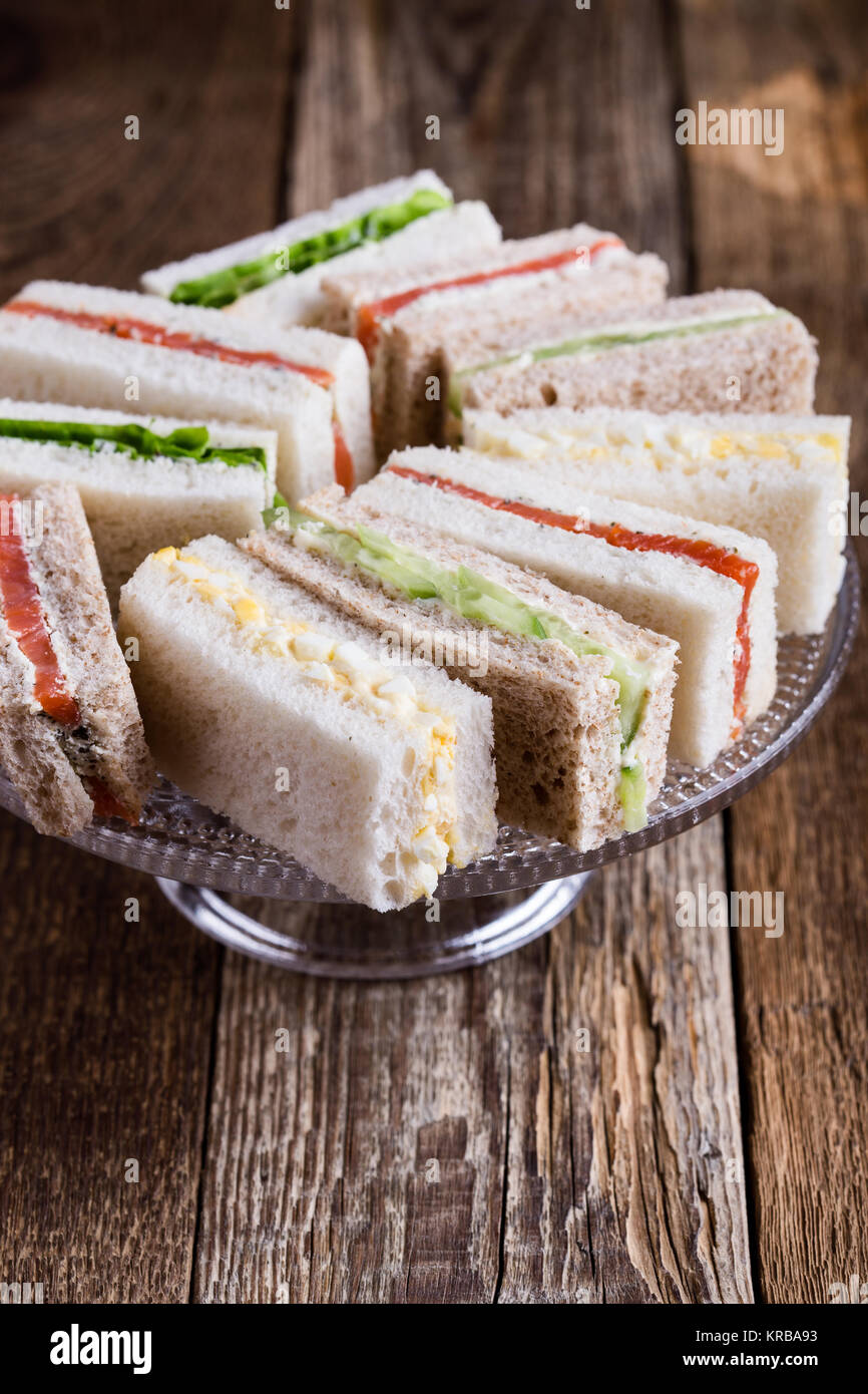 English tea sandwiches on cake over rustic wooden background Stock ...