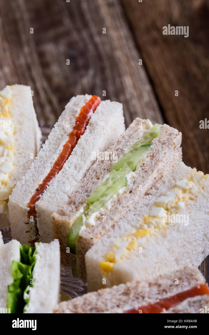 English tea sandwiches on cake over rustic wooden background Stock ...