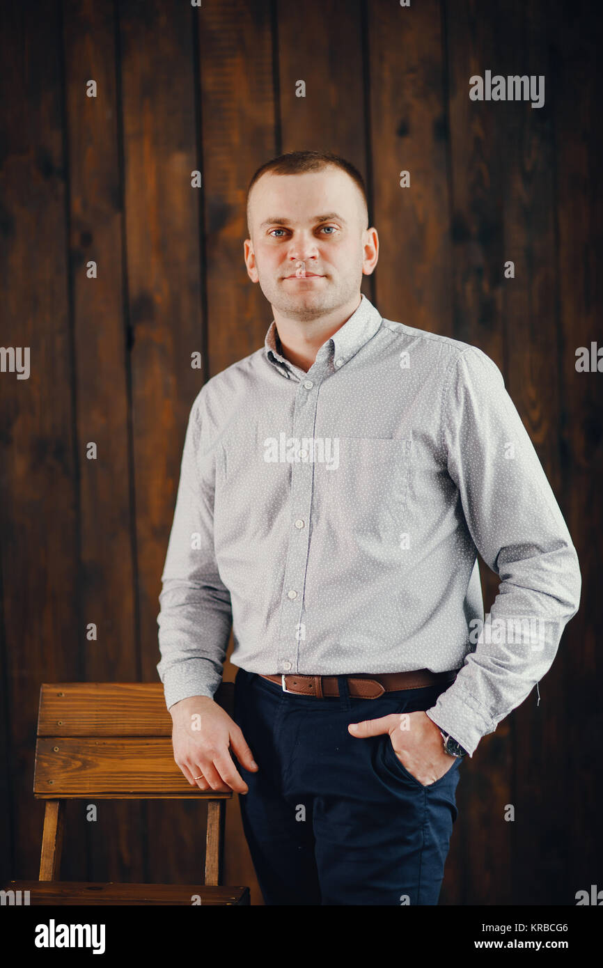 man standing next to a chair Stock Photo - Alamy