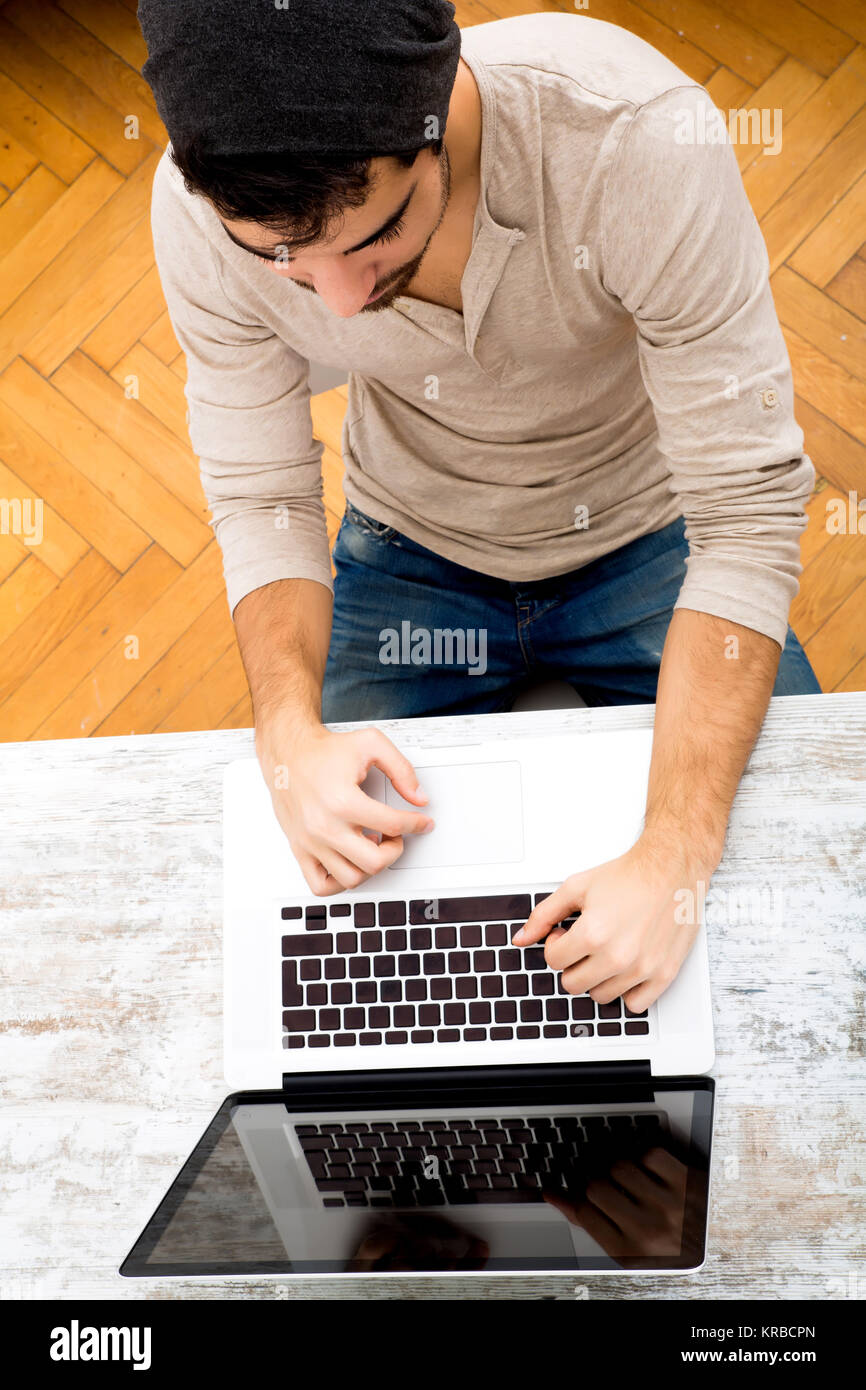 Young man typing on his laptop at home Stock Photo - Alamy