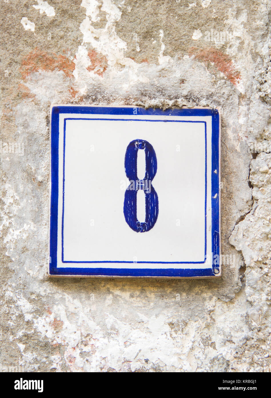 Number eight on the grey stone wall Stock Photo - Alamy