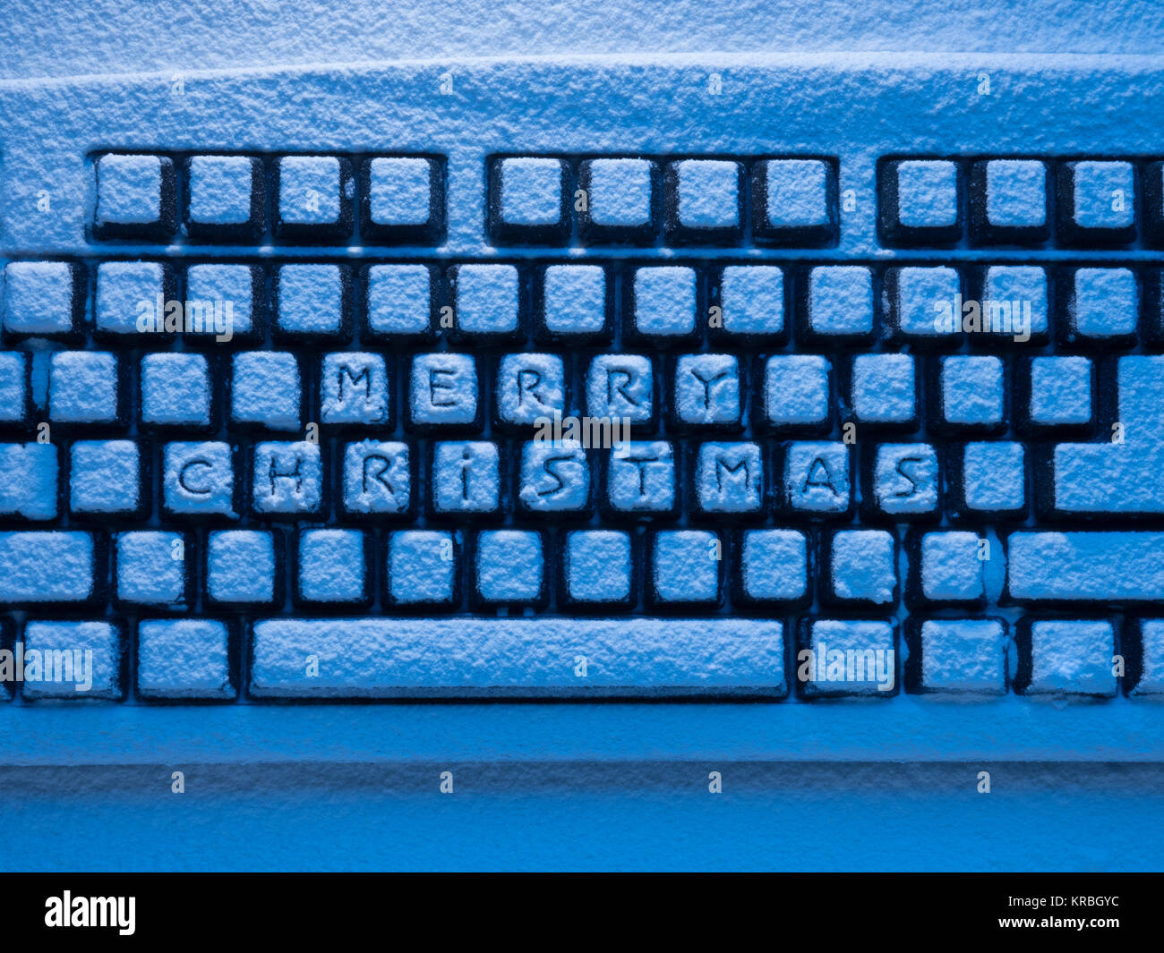 computer keyboard covered with snow illuminated by blue neon light with ...