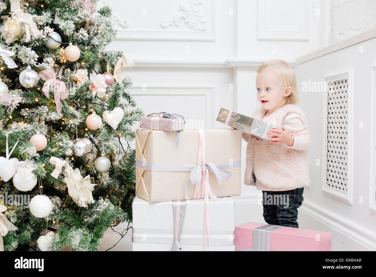portrait beautiful little girl Christmas tree in the background. keeps ...
