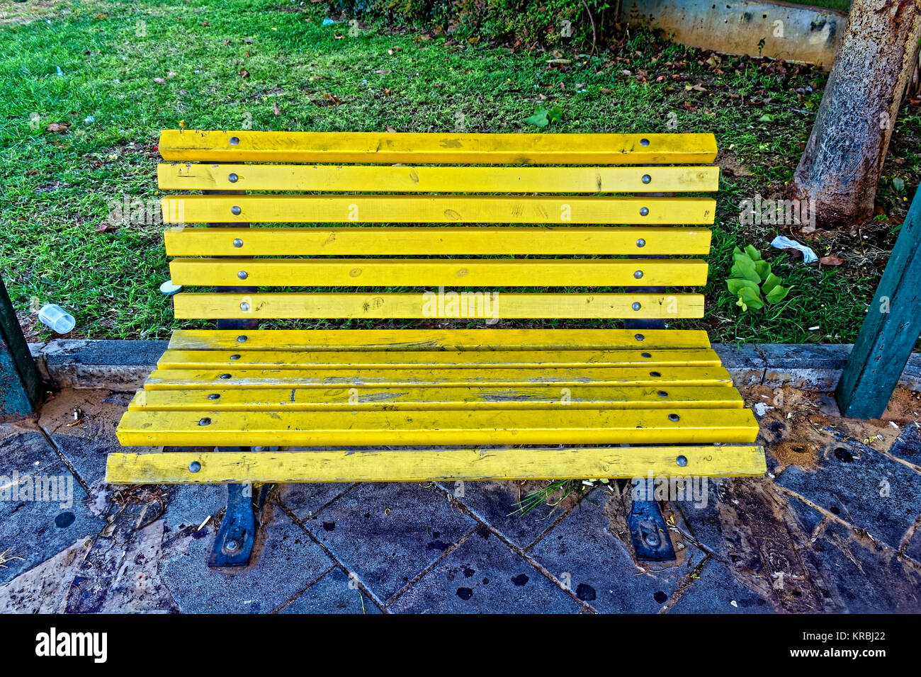yellow public wooden bench with bolts on a grass background Stock Photo ...