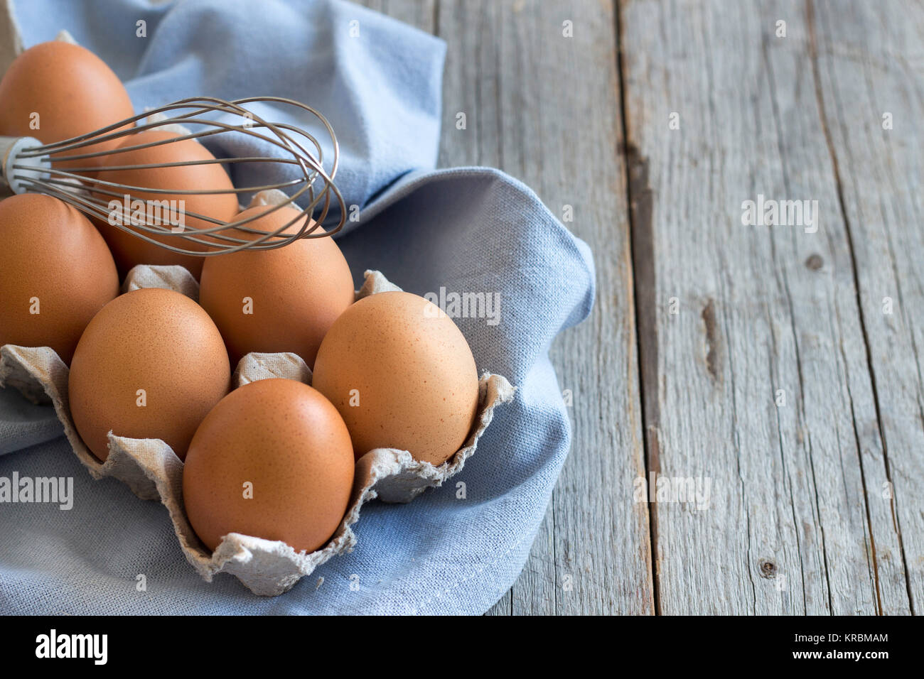 Chicken eggs and a whisk Stock Photo - Alamy