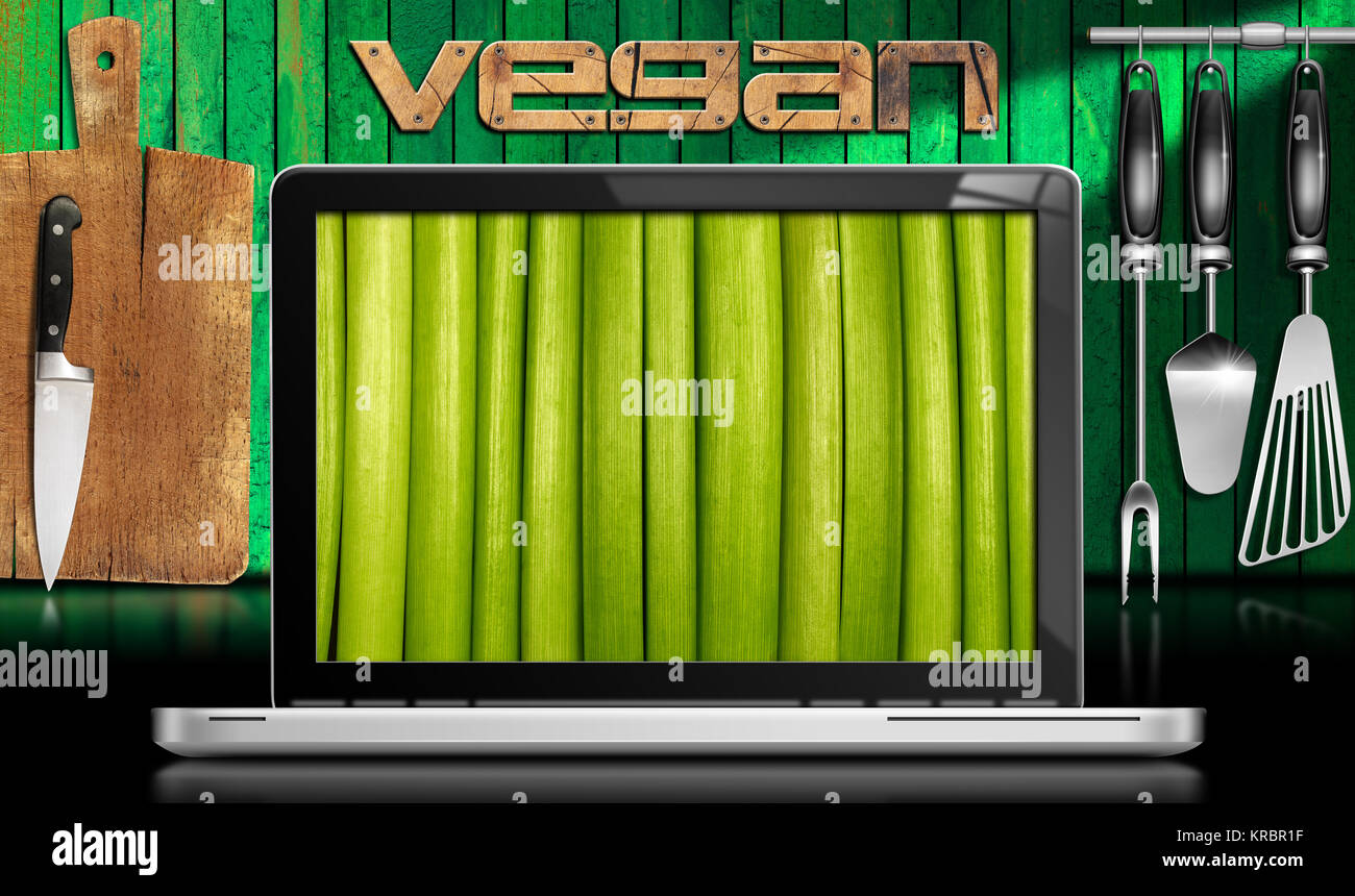 Laptop computer with green vegetables in the screen in a kitchen with ...