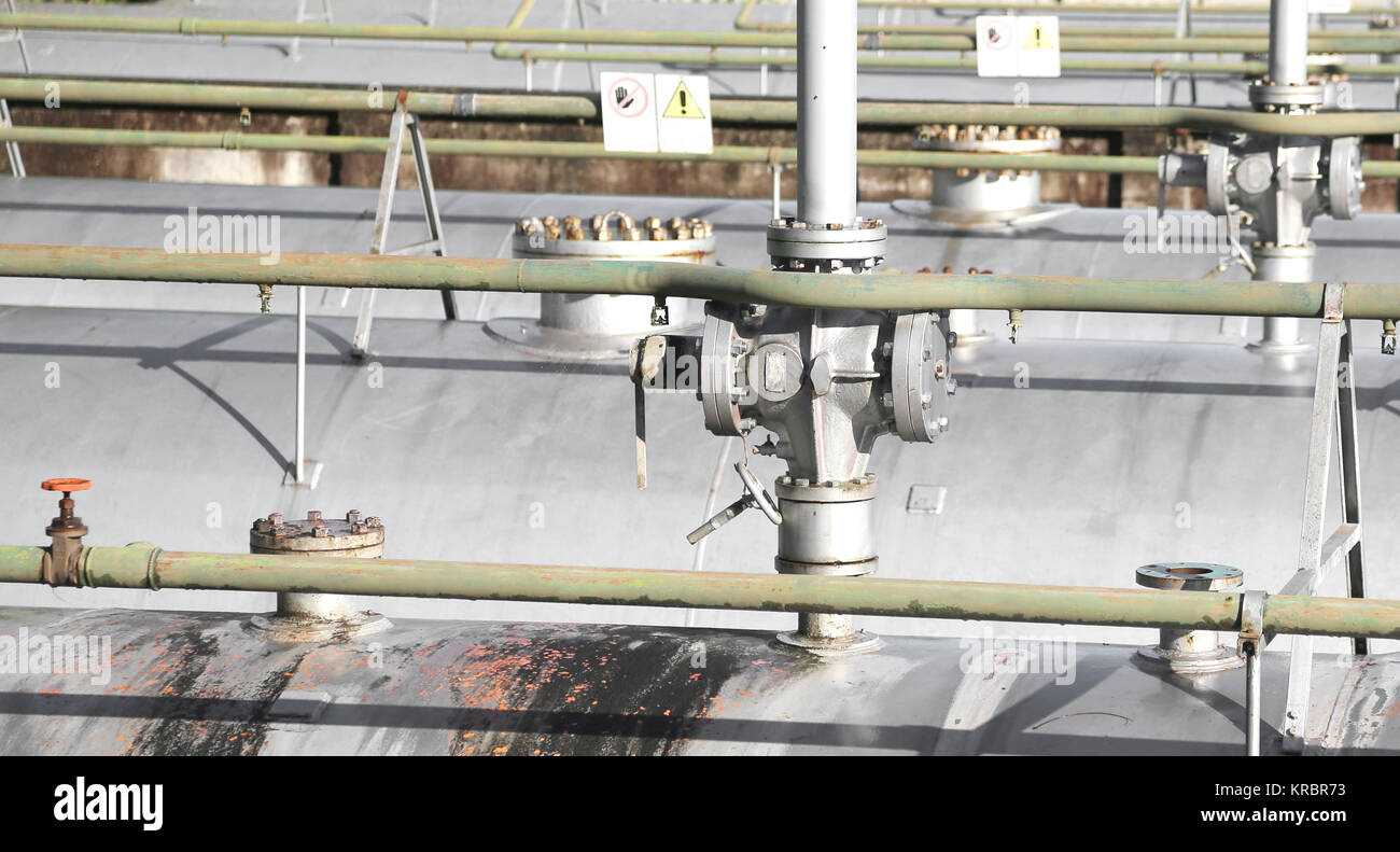big metallic safety valve on the large storage tank for gas inside and ...