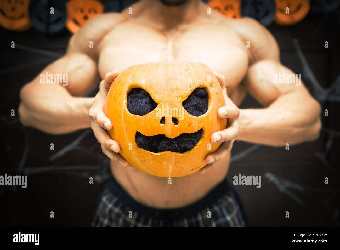 Halloween bodybuilder with pumpkin Stock Photo - Alamy