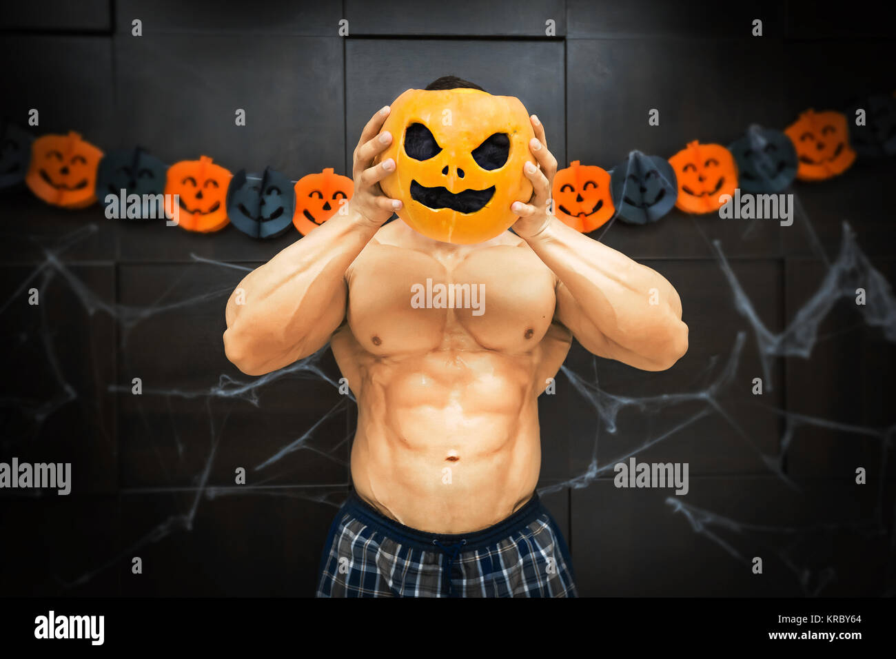 Halloween bodybuilder with pumpkin Stock Photo - Alamy