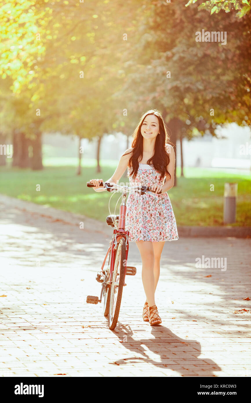 The young girl with bicycle in park Stock Photo - Alamy