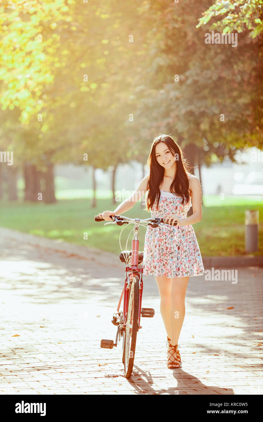 The young girl with bicycle in park Stock Photo - Alamy