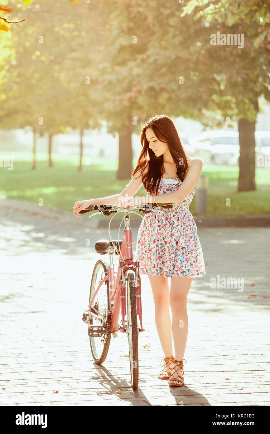 The young girl with bicycle in park Stock Photo - Alamy