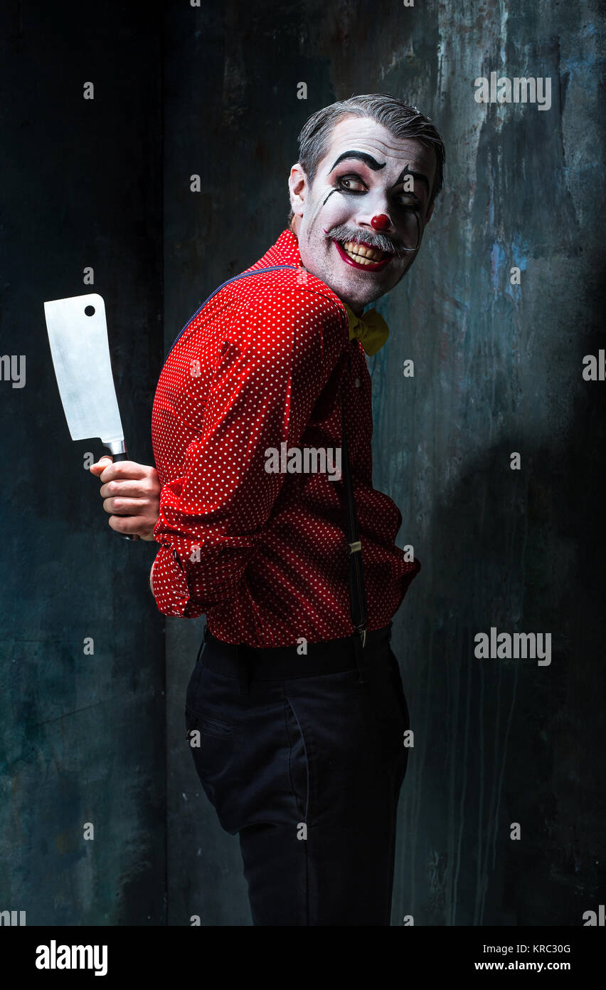 The scary clown holding a knife on dack. Halloween concept Stock Photo ...