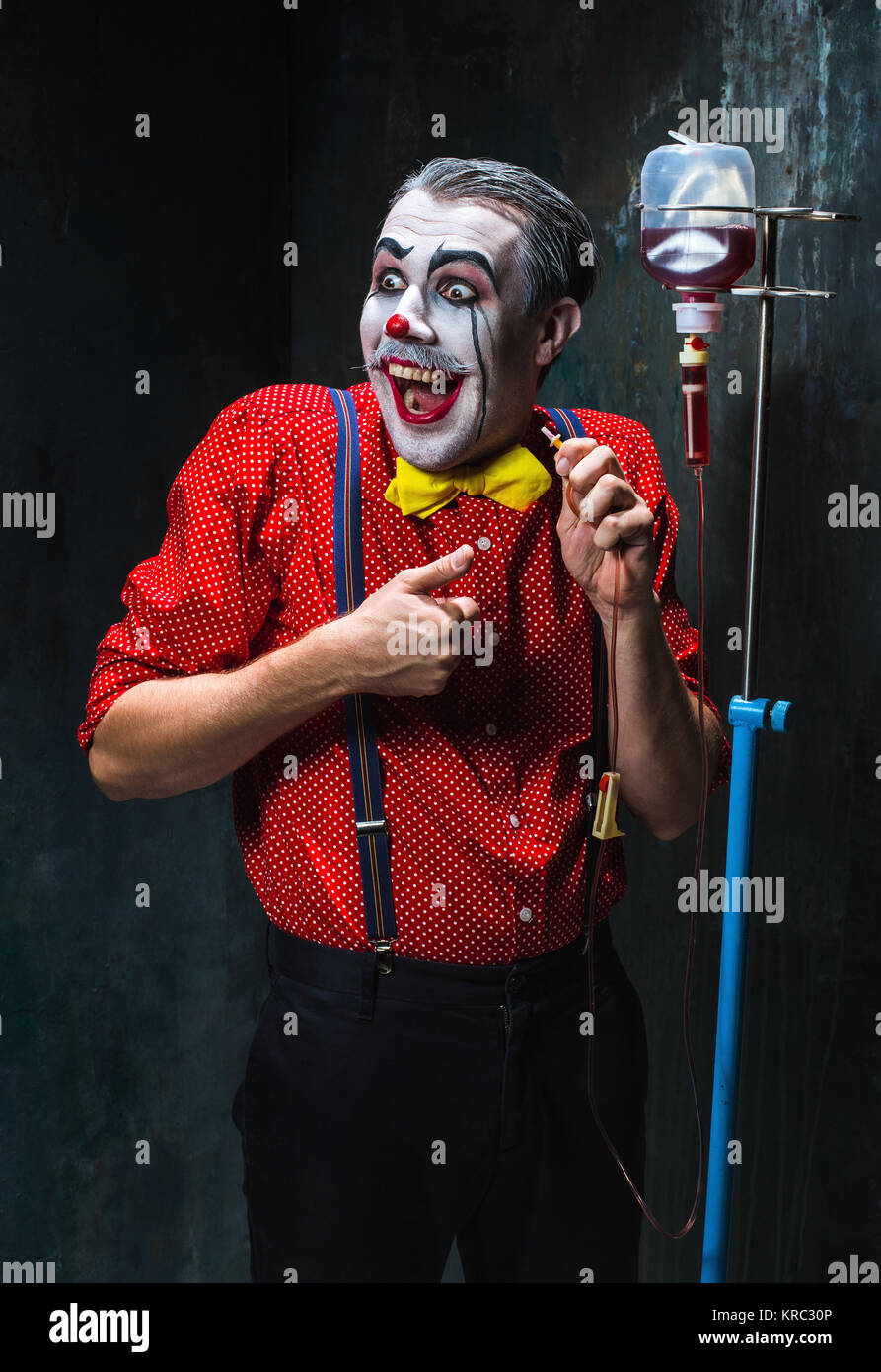 The scary clown and drip with blood on dack background. Halloween ...