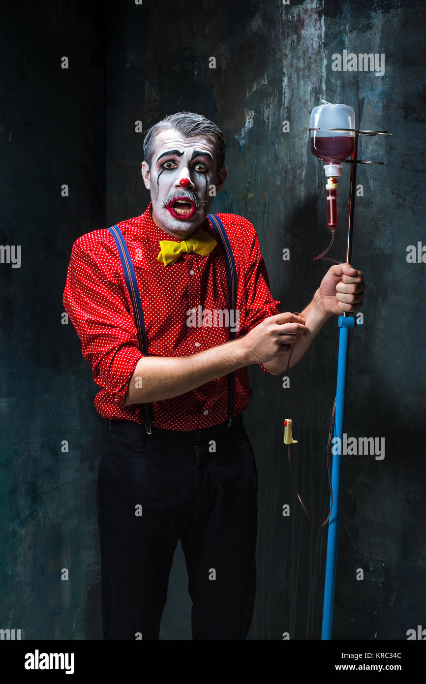 The scary clown and drip with blood on dack background. Halloween ...
