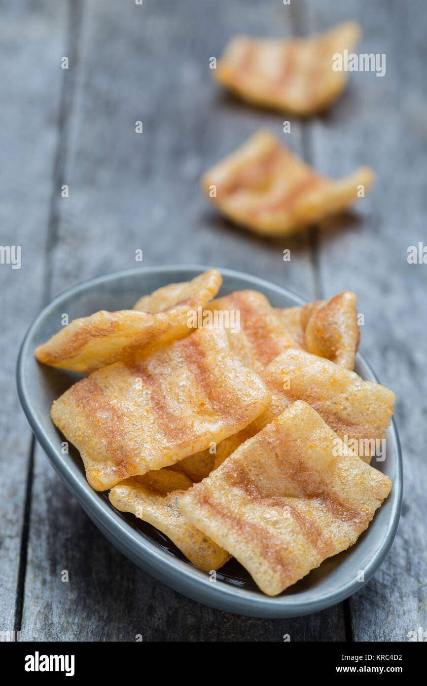 Bacon chips on gray rustic wood Stock Photo - Alamy