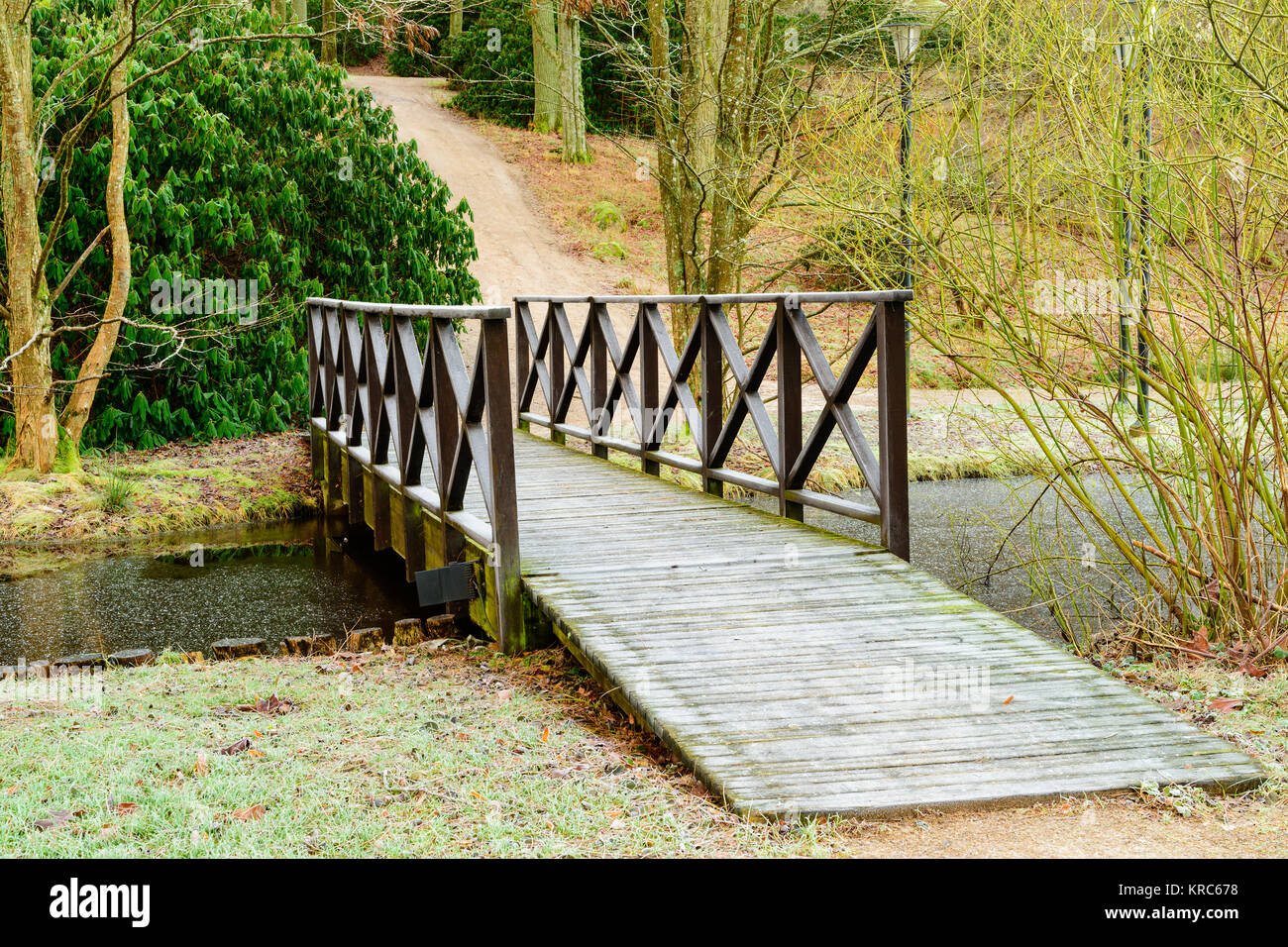 Small wooden walk bridge over frozen canal in public park. Location ...