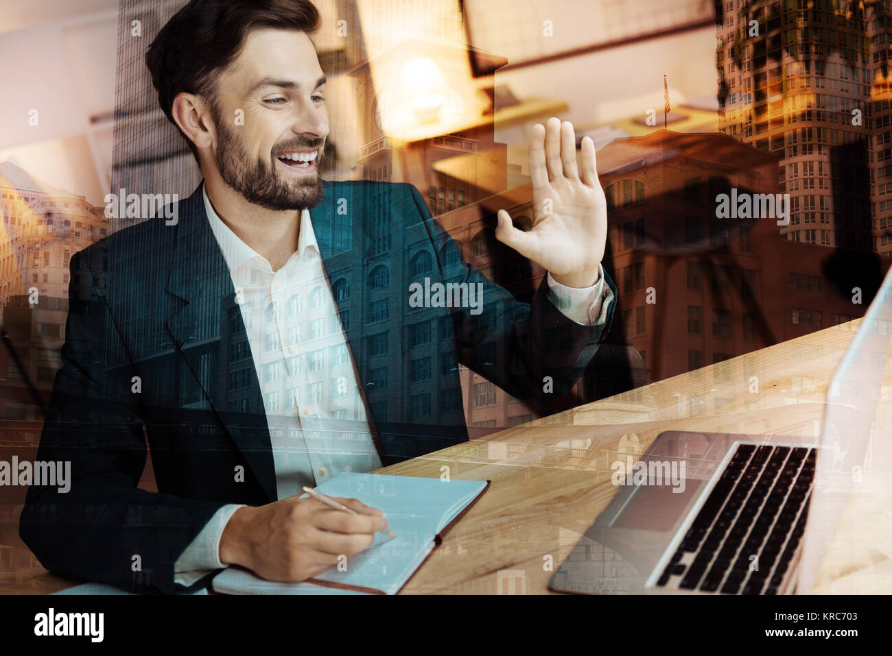 Cheerful businessman greeting his interlocutor through web camera Stock ...