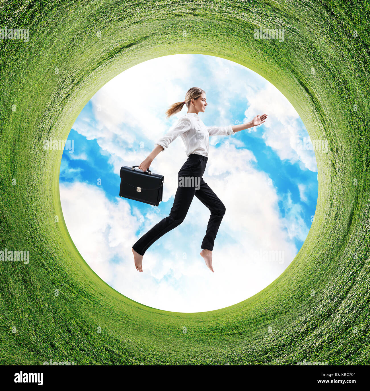 Business woman jumps in formal wear in rotated field with green grass ...