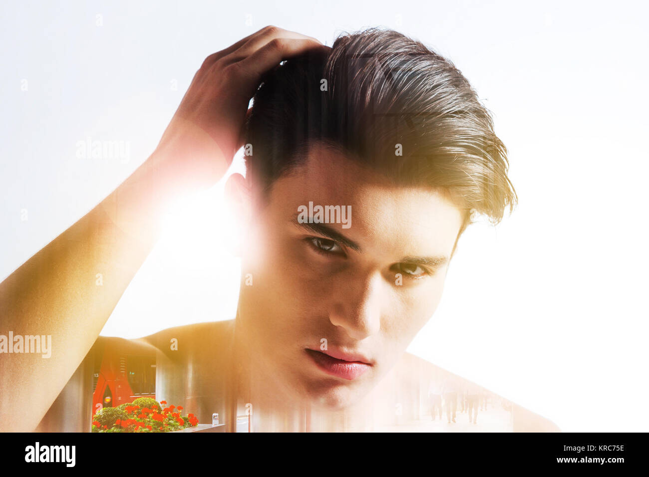 Serious attractive man touching his hair Stock Photo - Alamy