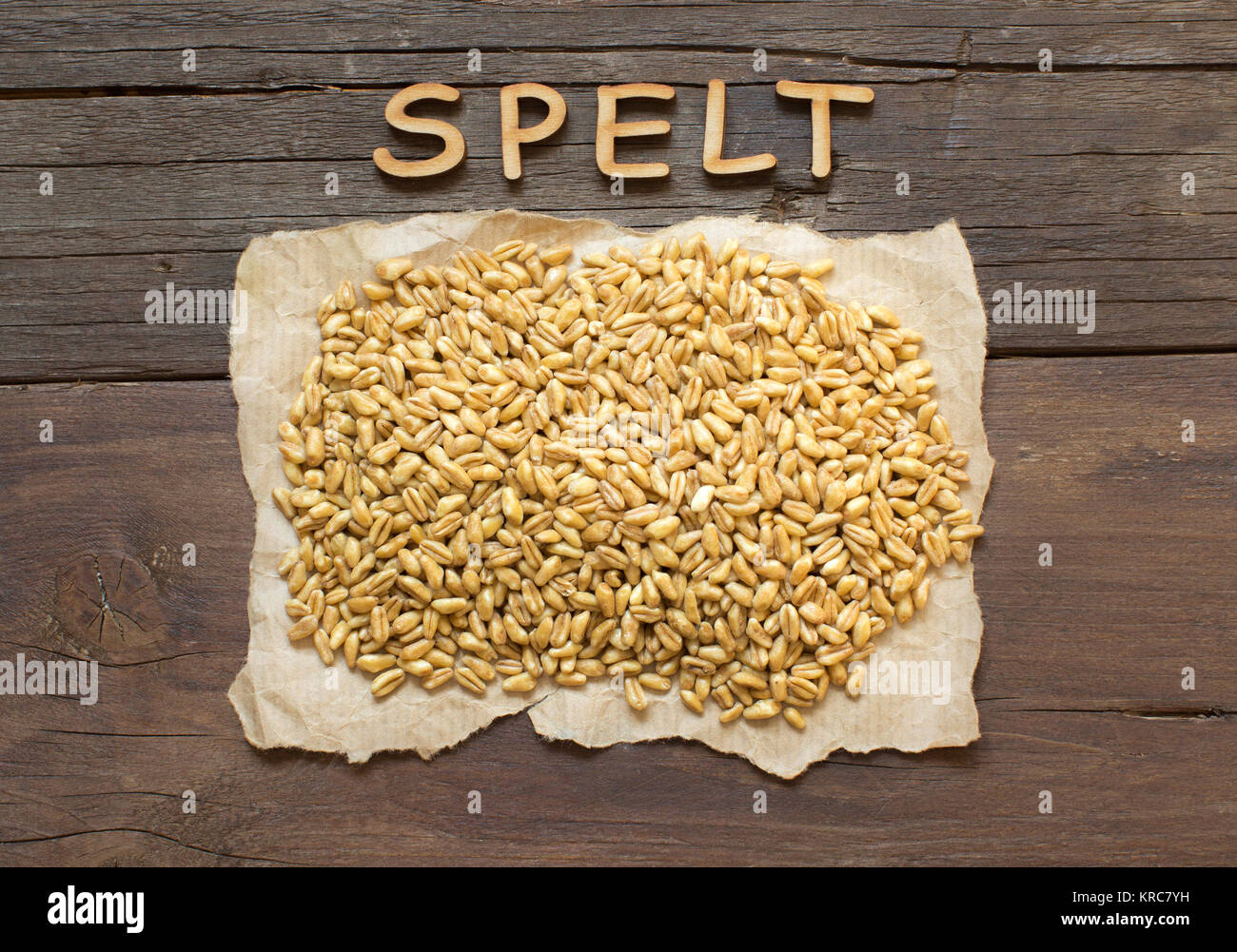 Raw Organic spelt grain with wooden word Stock Photo - Alamy