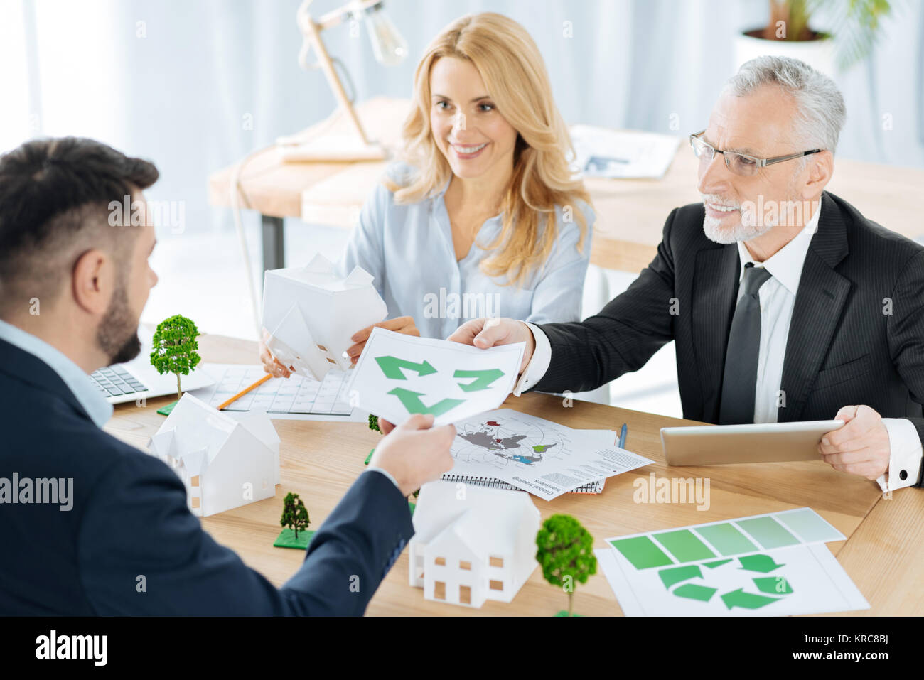 Responsible engineers holding recycling symbol and looking happy Stock ...
