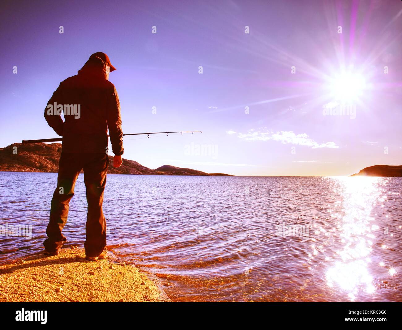 Fisherman check pushing bait on the fishing line, throw lure into blue ...