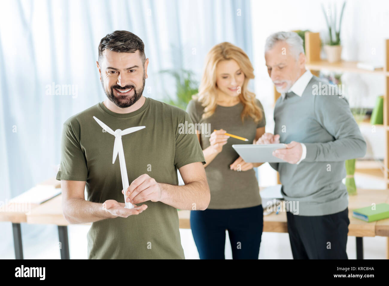 Emotional engineer feeling excited while holding a windmill turbine ...