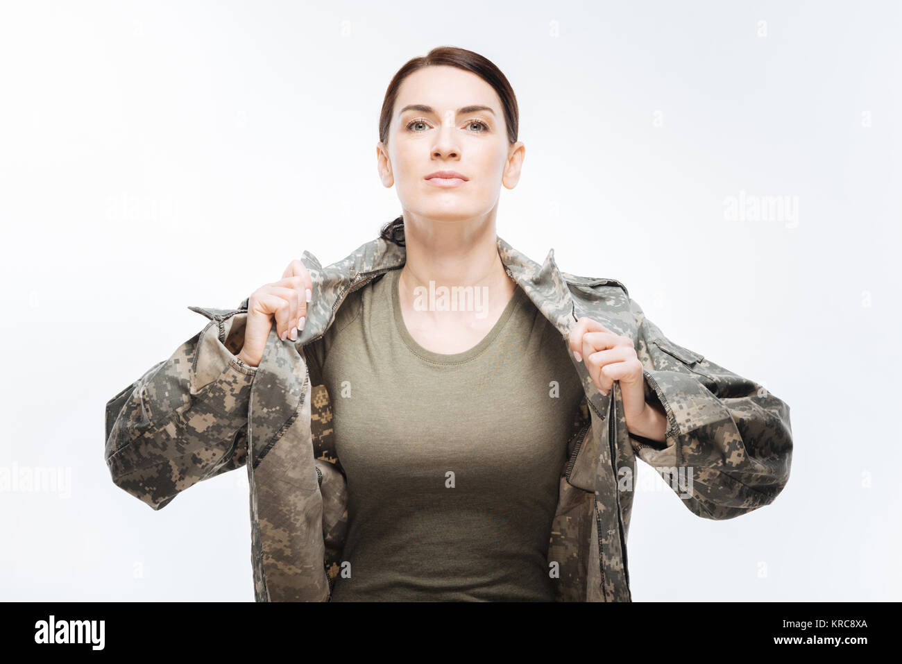 Earnest ambitious woman taking on uniform Stock Photo - Alamy