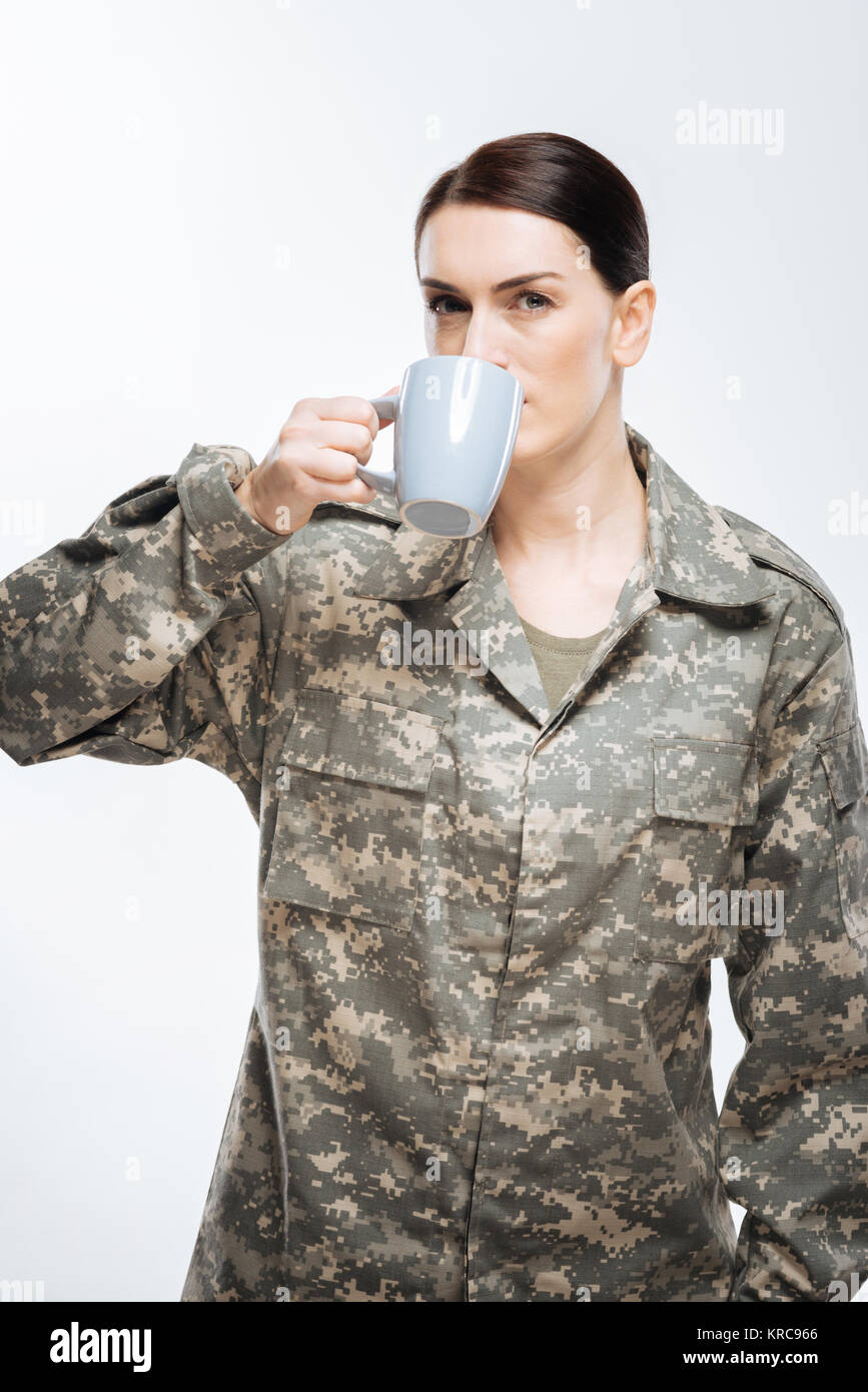 Musing female soldier drinking coffee Stock Photo - Alamy