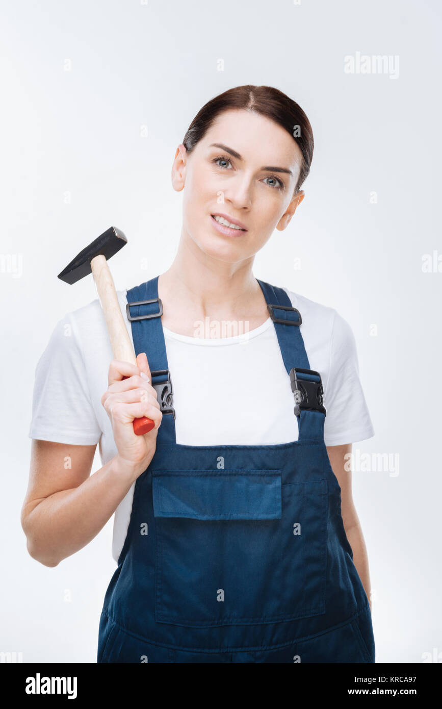 Adorable female worker standing with hammer Stock Photo - Alamy