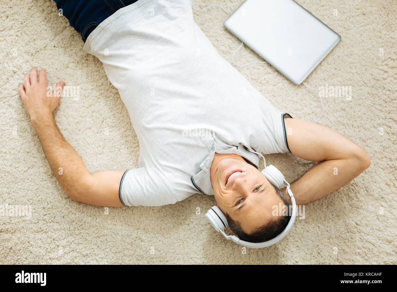 Cheerful emotional man relaxing while listening to his favorite music ...