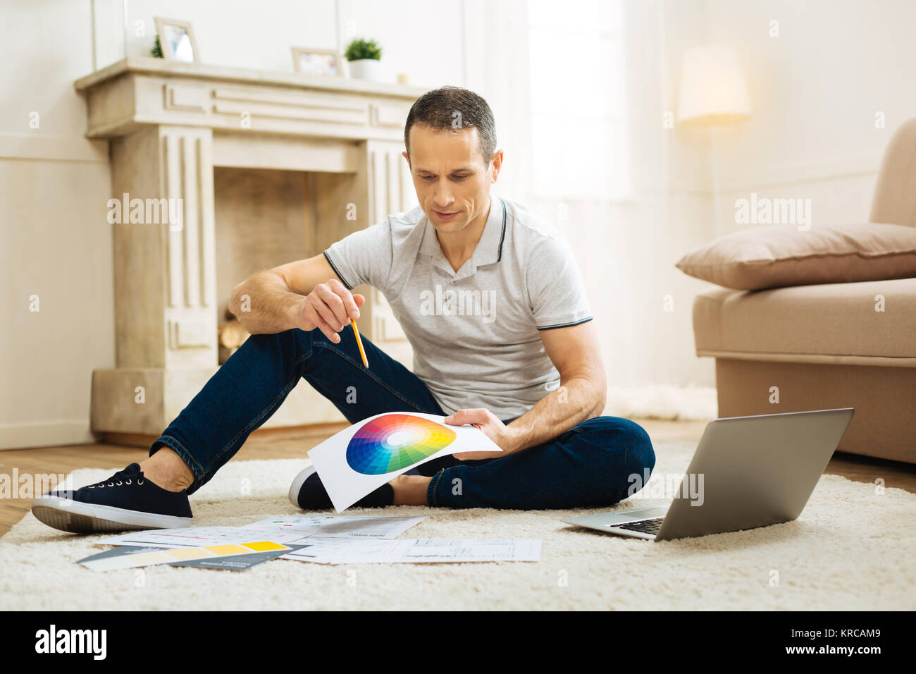 Smart calm designer holding a color palette and thinking Stock Photo ...
