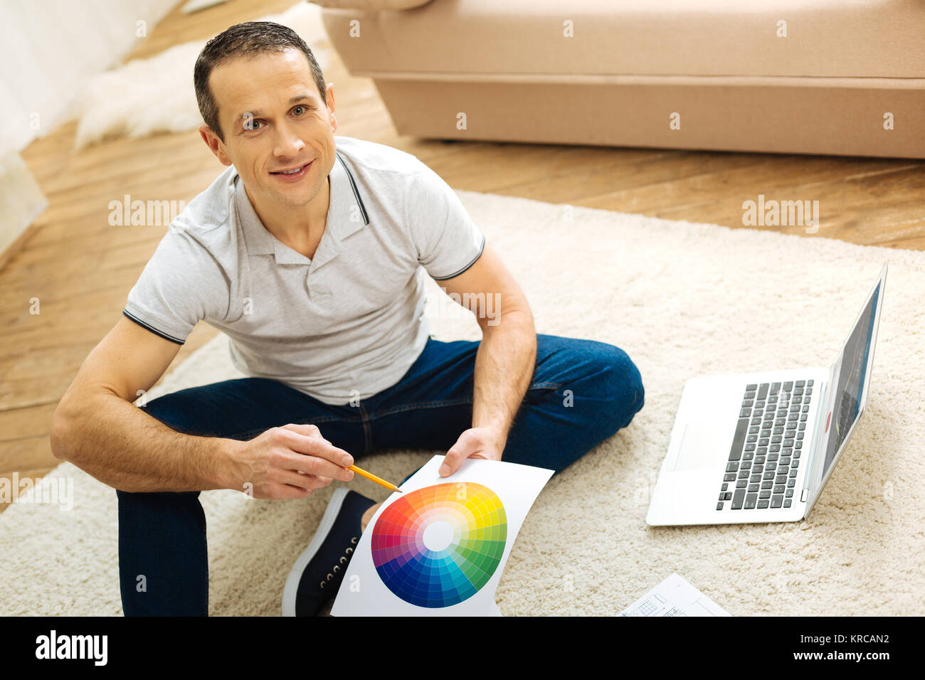 Cheerful young designer feeling happy while sitting with a color ...