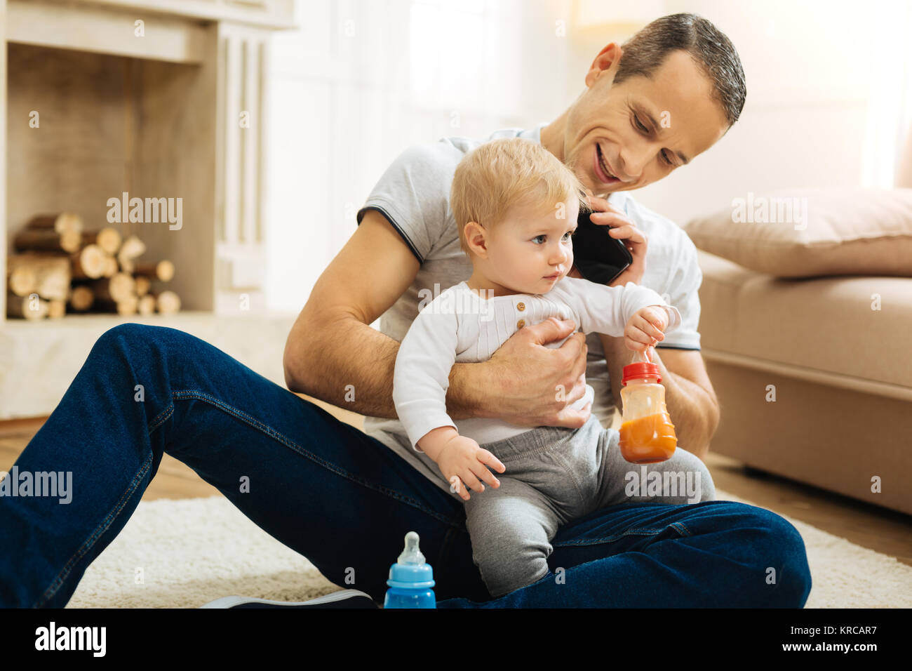 Kind loving father organizing a phone talk for his child and smiling ...